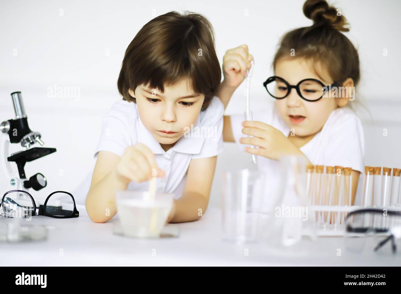 Two cute children at chemistry lesson making experiments isolated on ...
