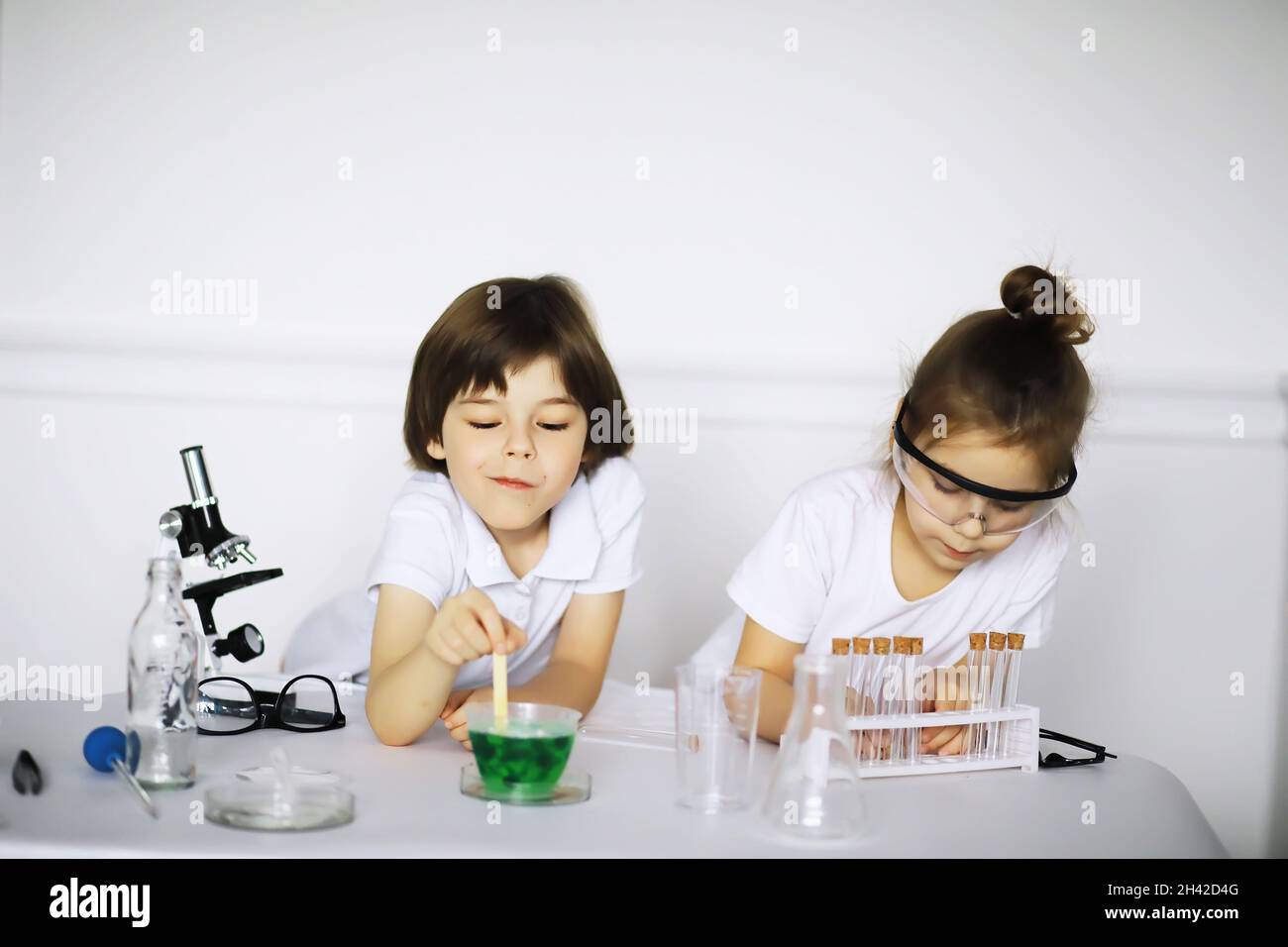 Two cute children at chemistry lesson making experiments isolated on ...