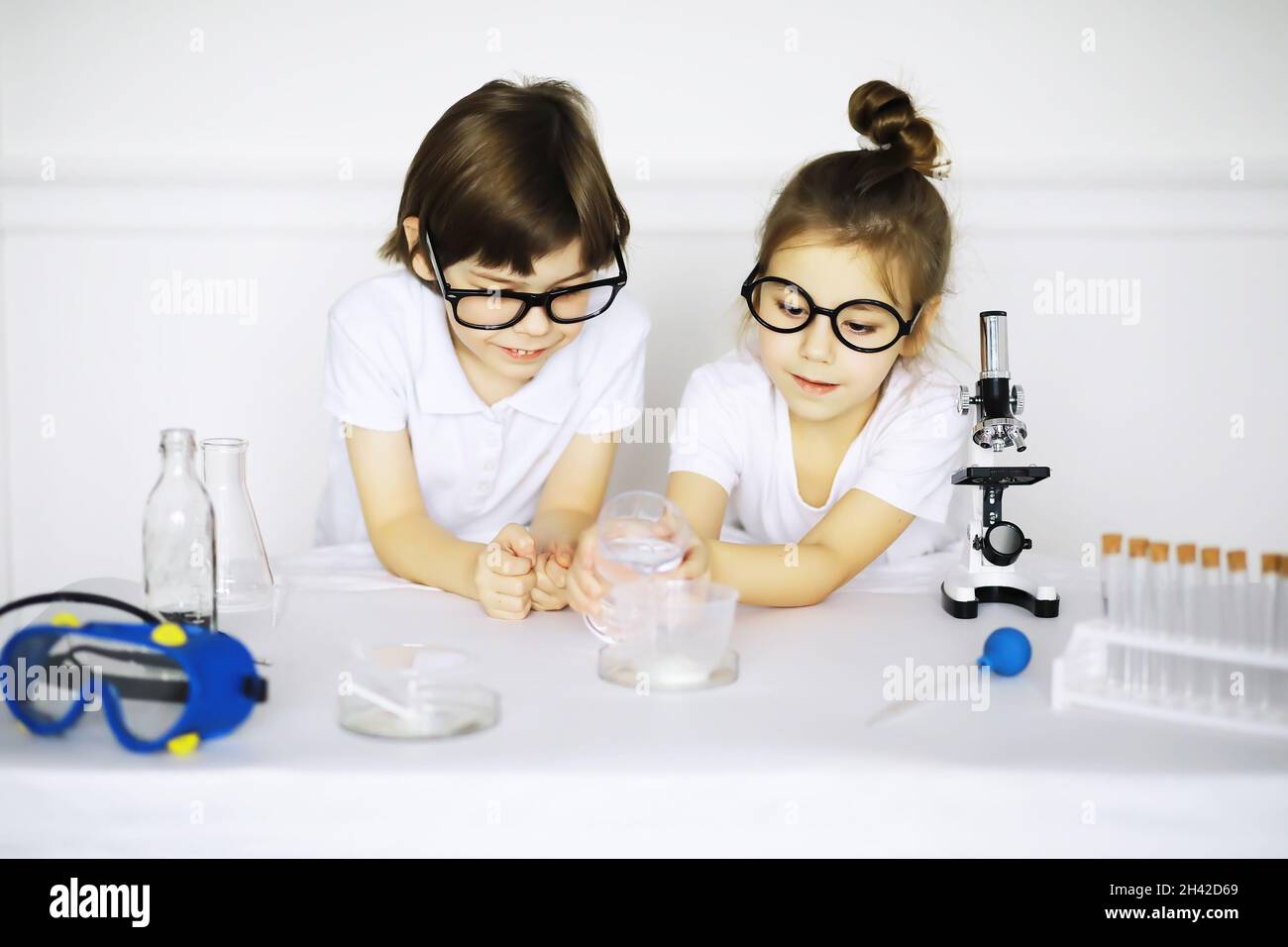 Two cute children at chemistry lesson making experiments isolated on ...