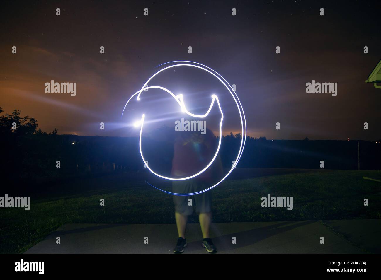 A guy making a circle signs with laser lights Stock Photo - Alamy