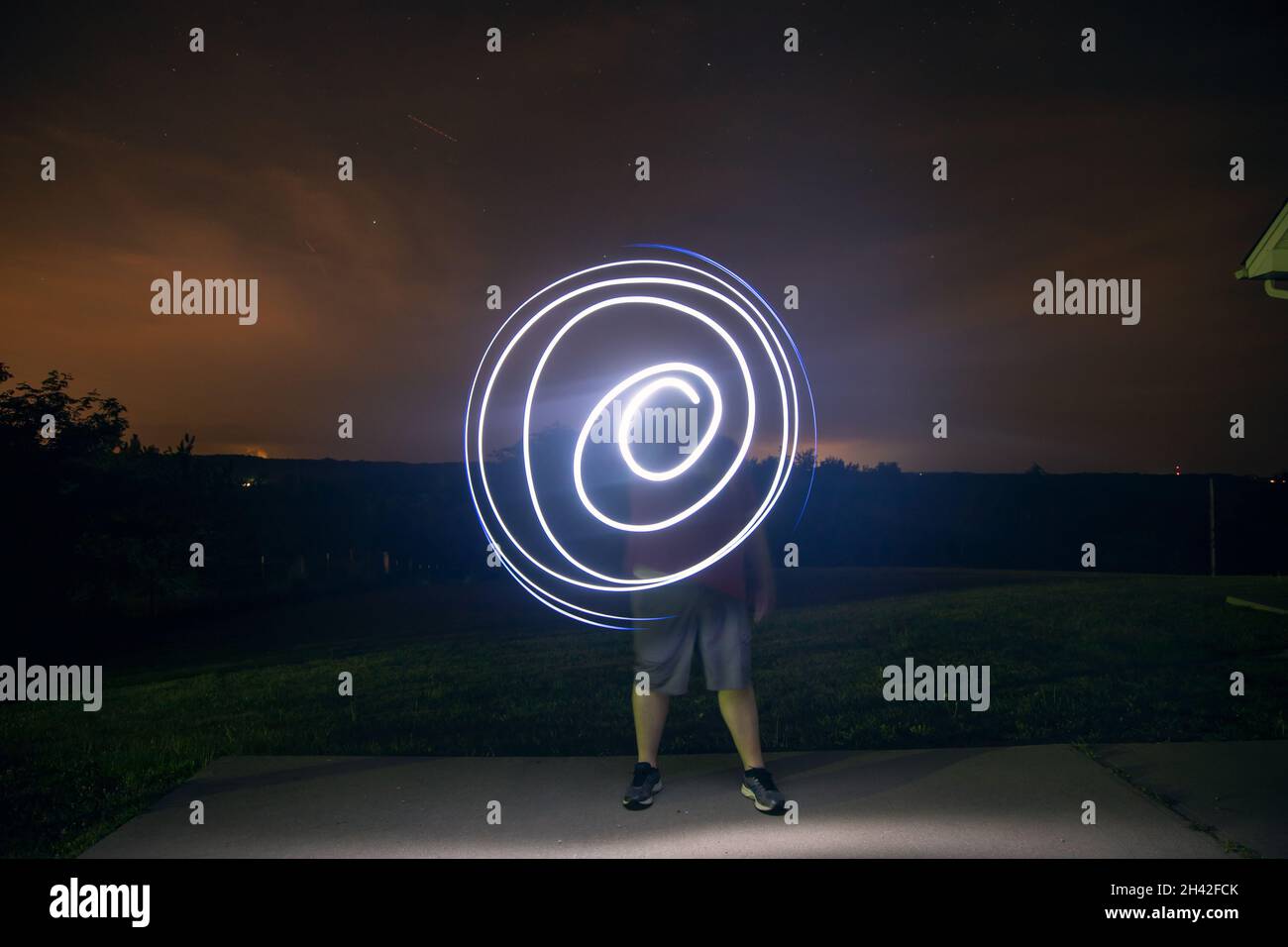 A guy making a circle signs with laser lights Stock Photo - Alamy
