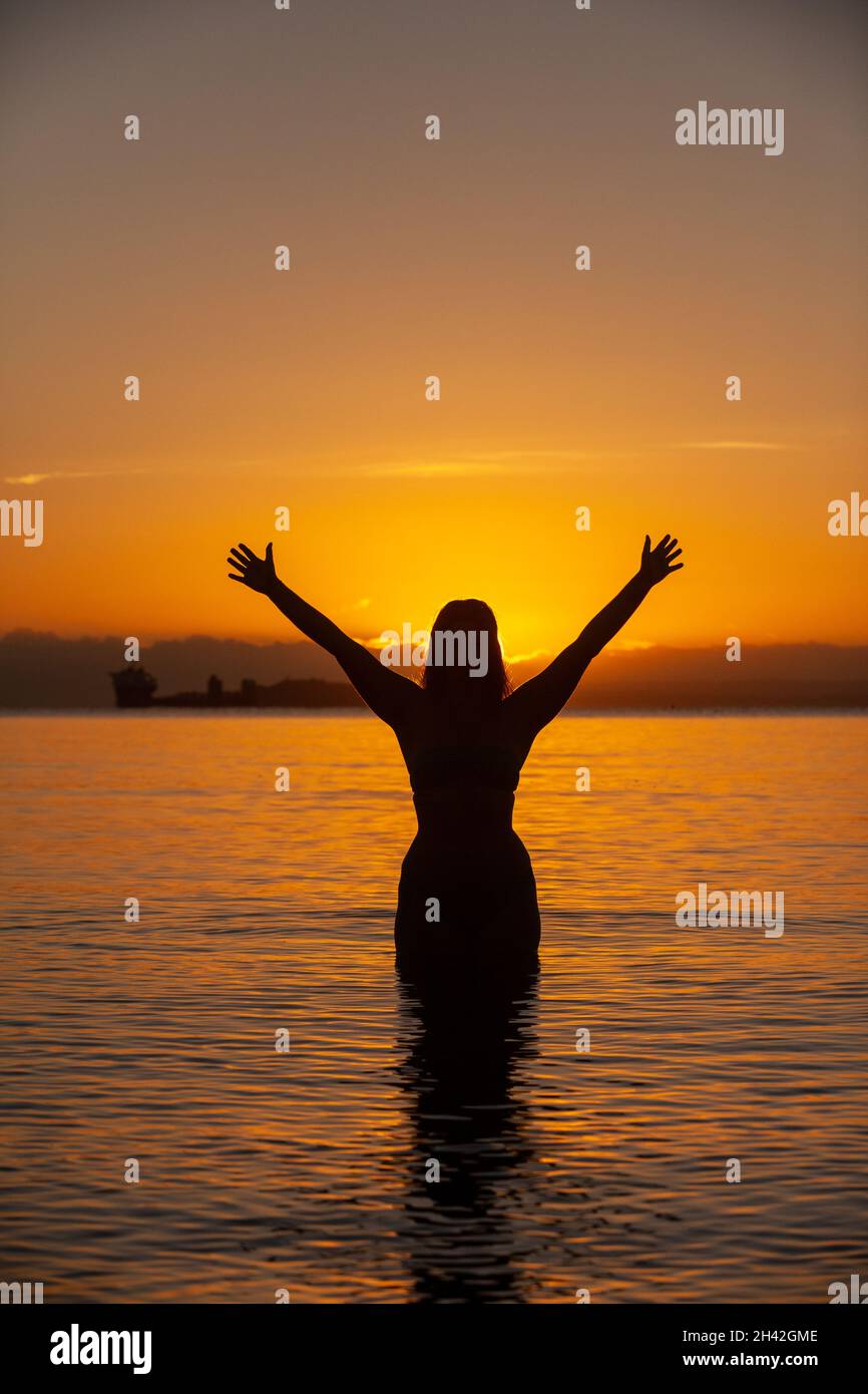 Woman standing sea raised arms hi-res stock photography and images - Alamy
