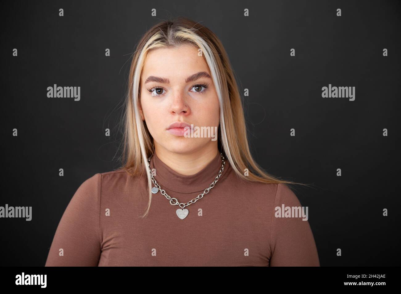 Teenage girl looking towards camera with a neutral expression Stock ...