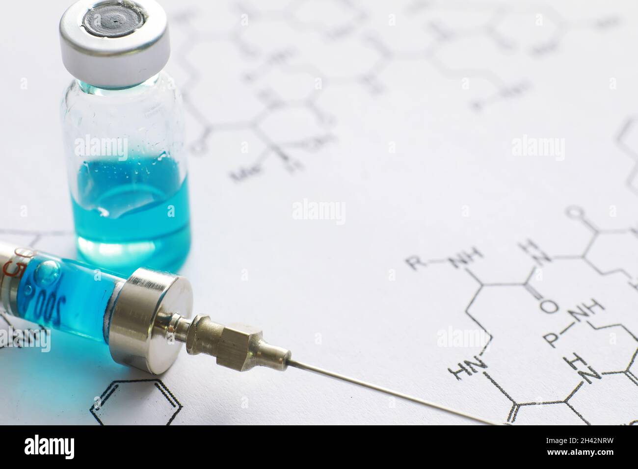 small jars with injection and syringe for injection on blue background ...