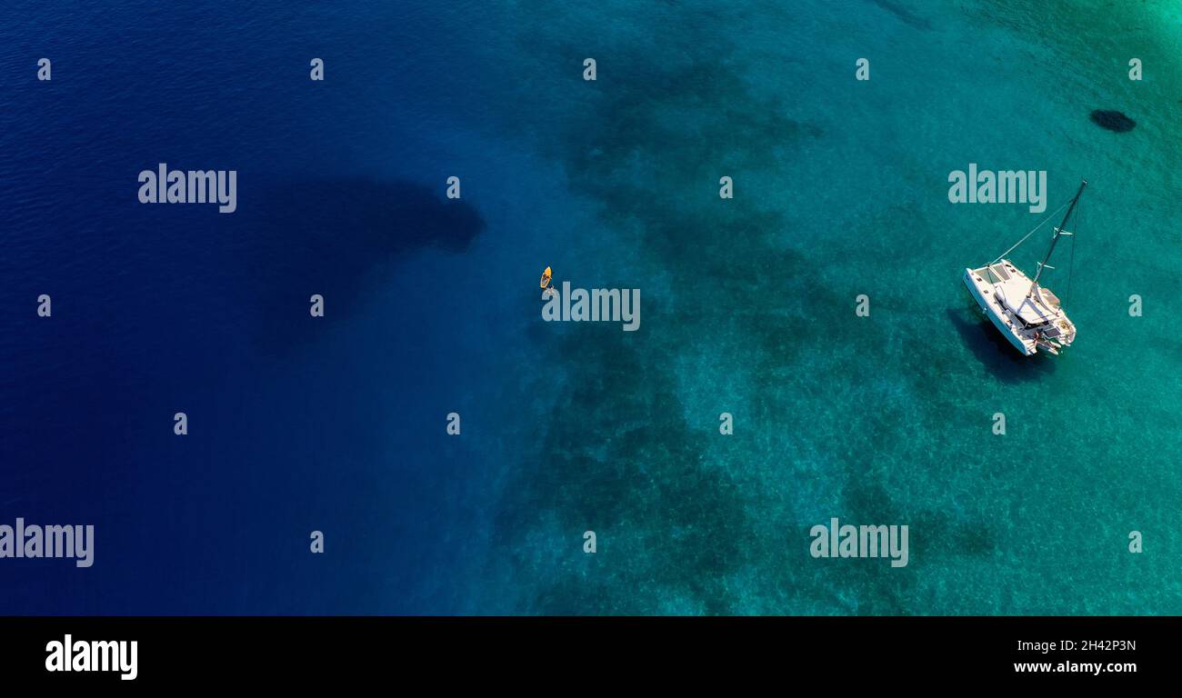 Aerial photo of yellow canoe close to catamaran boat at tranquil ...
