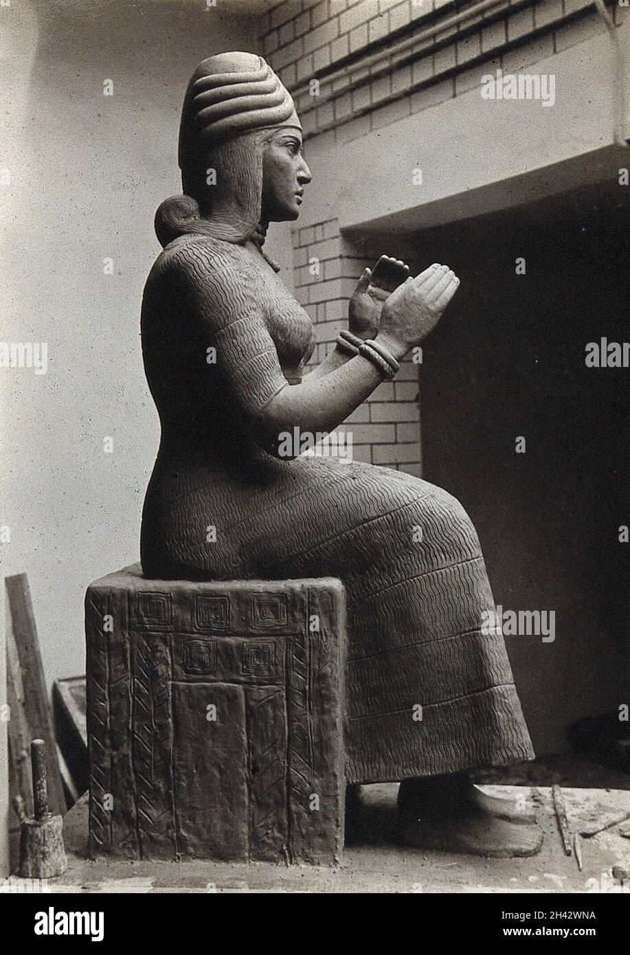 A sculpture of Gula, Mesopotamian deity of healing, with a dog at her ...