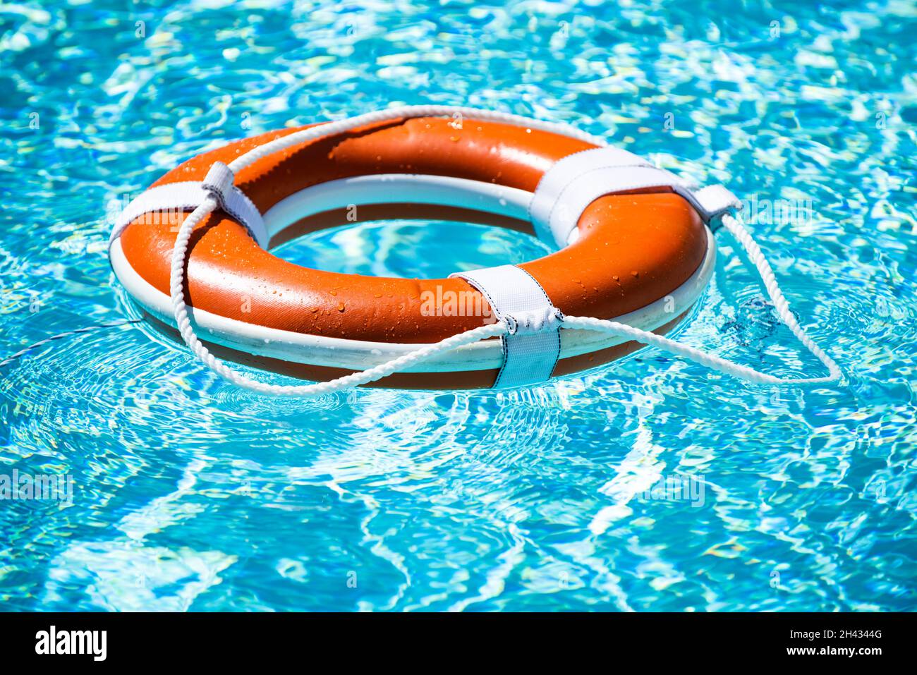 Lifebuoy pool ring float on blue water Stock Photo - Alamy