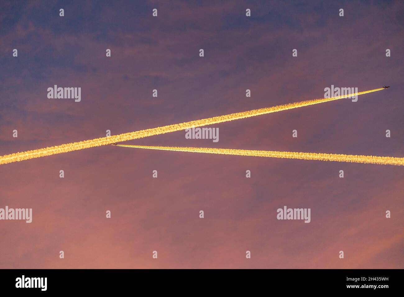 Airliner at high altitude with condesation trails Stock Photo - Alamy