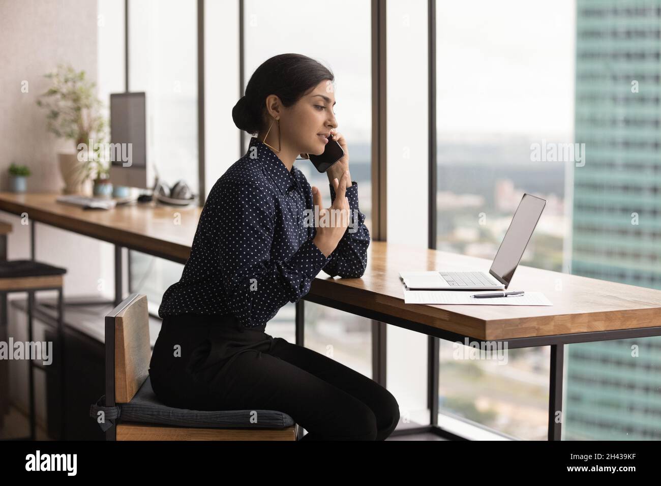 Concentrated young busy indian businesswoman multitasking in office ...