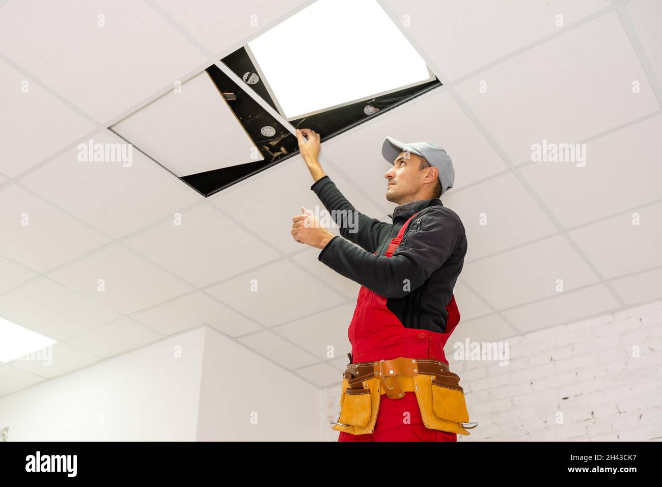 Builder replacing ceiling panel, working, ceiling armstrong Stock Photo ...