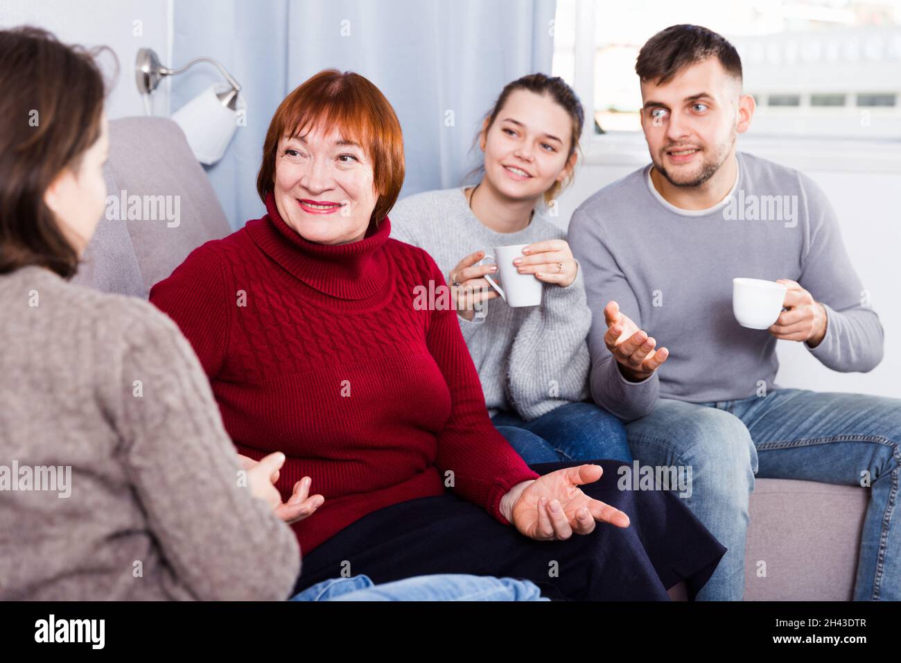 Family enjoying conversation with female Stock Photo - Alamy