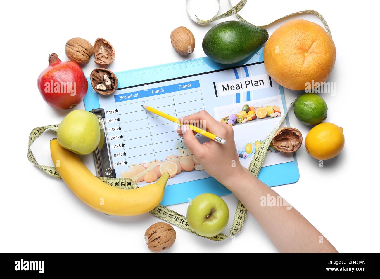 Woman with healthy food filling out meal plan on white background Stock ...