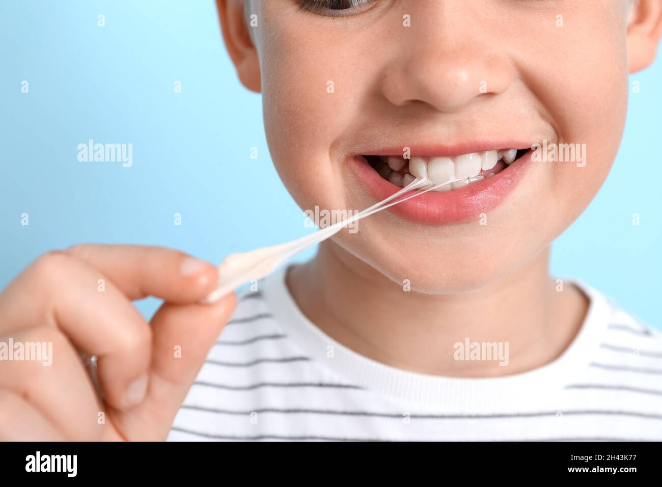 Little boy with chewing gum on blue background, closeup Stock Photo - Alamy