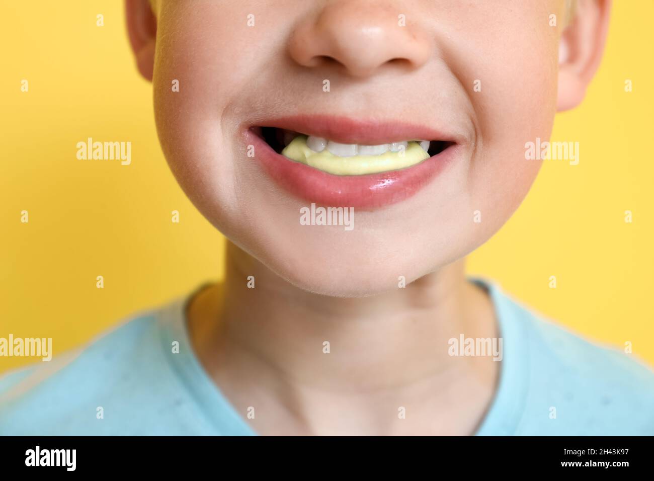 Little boy chewing gum on yellow background, closeup Stock Photo - Alamy