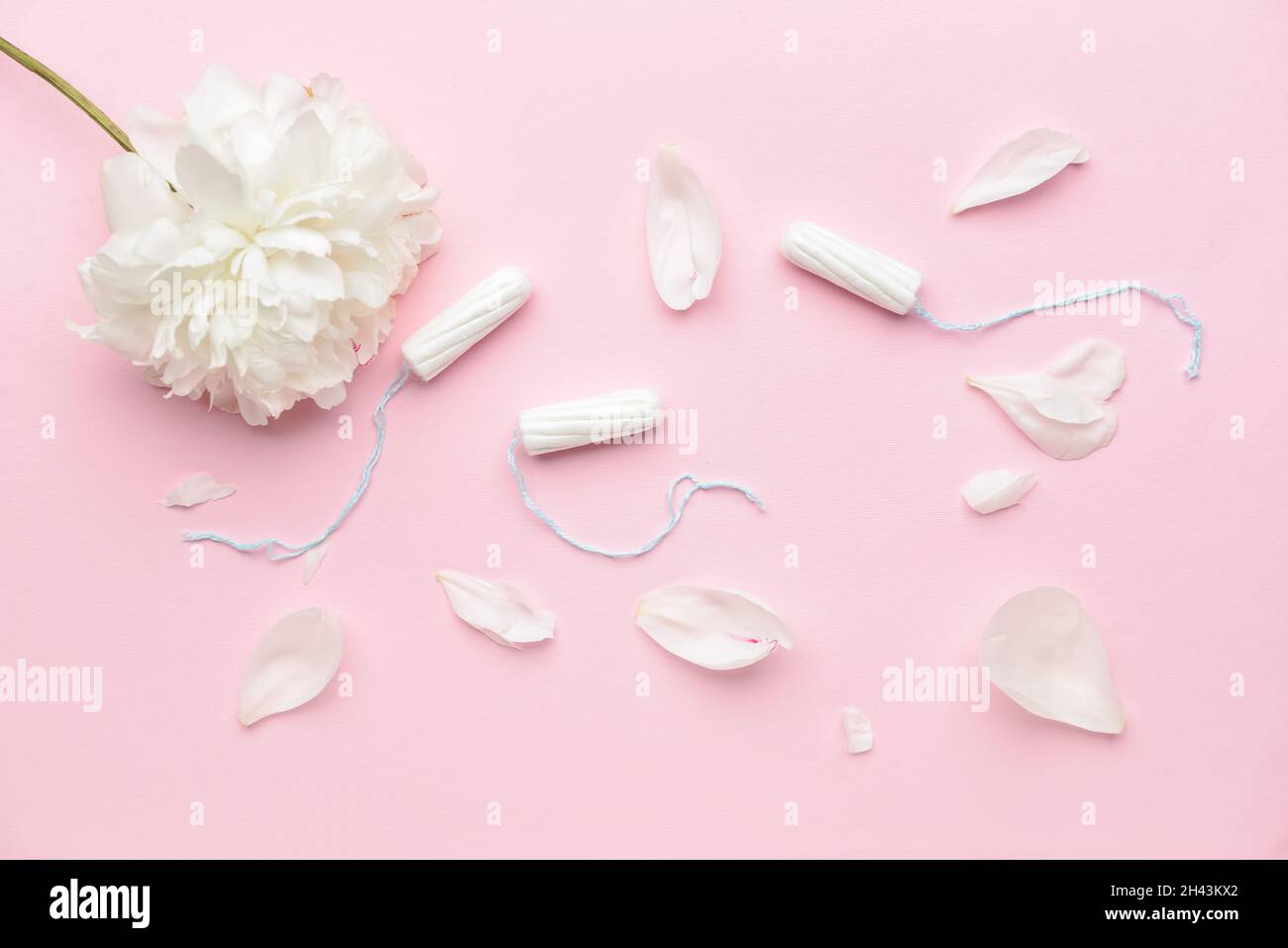 Menstrual tampons and flower on pink background Stock Photo - Alamy