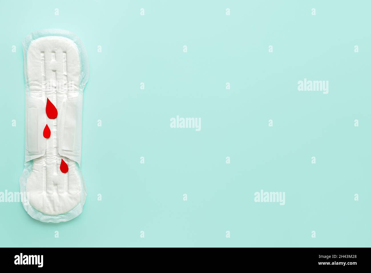 Menstrual pad and paper blood drops on blue background Stock Photo - Alamy