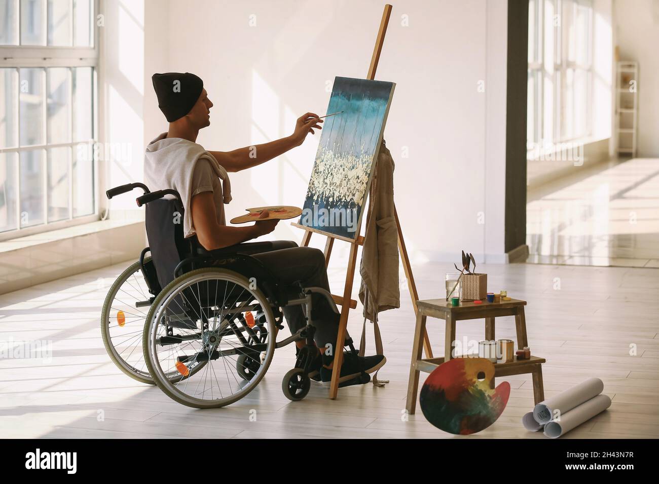 Young handicapped artist painting in workshop Stock Photo - Alamy