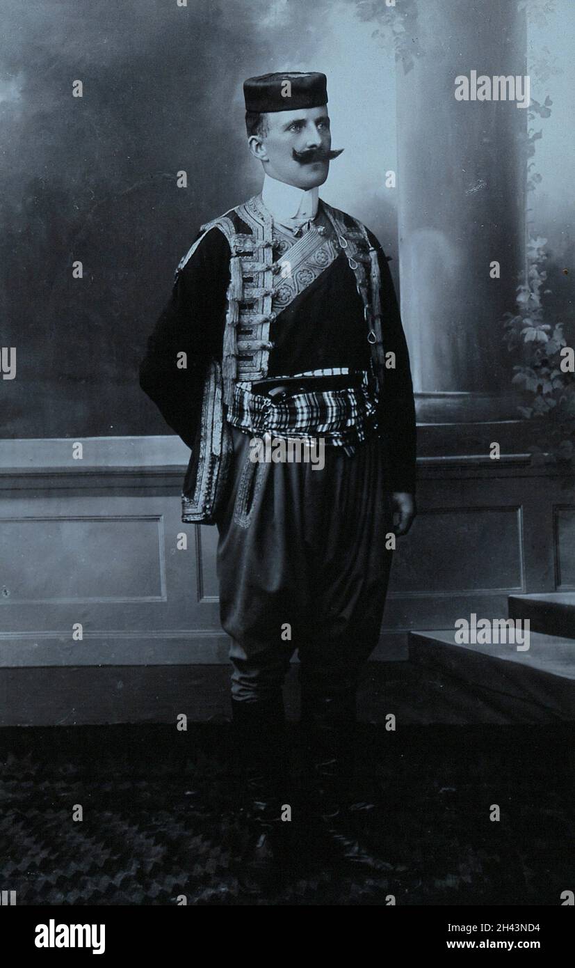 A Serbian man, wearing national dress with a fez, in front of a painted ...