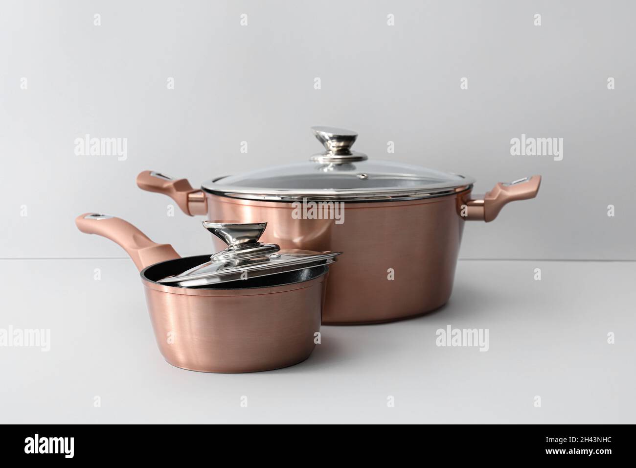 Metal cooking pots on light background Stock Photo - Alamy