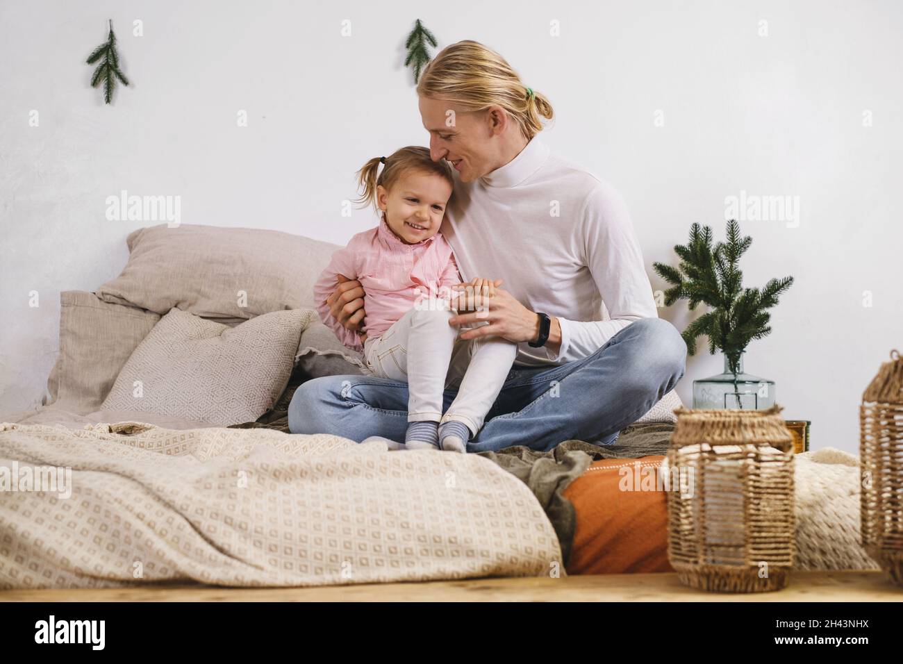 Father with child getting ready for Christmas in bed with real pot tree ...