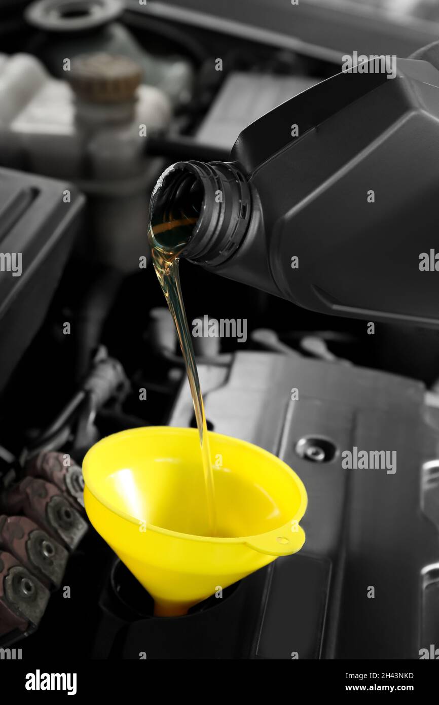 Pouring motor oil from canister into car engine Stock Photo - Alamy