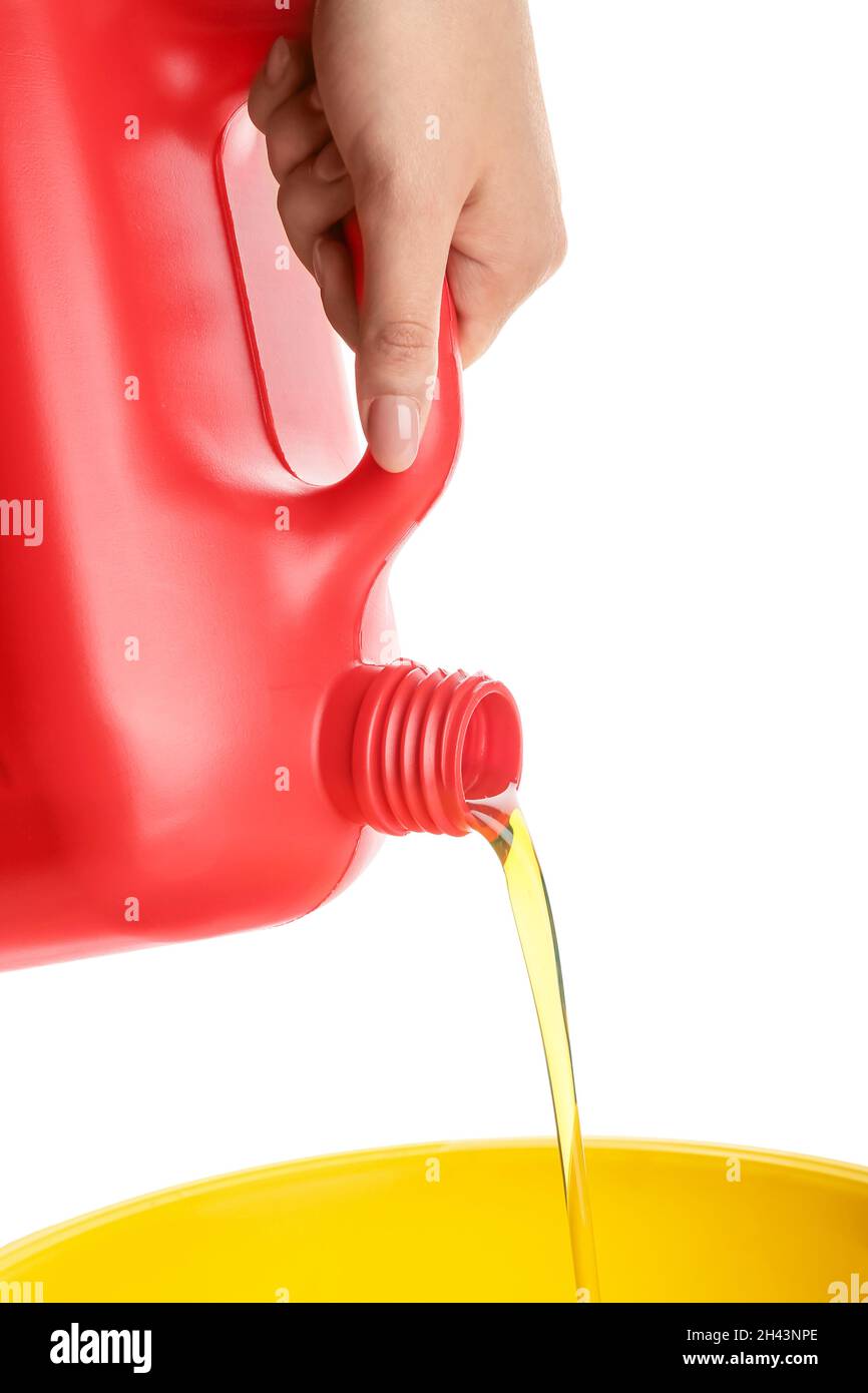 Woman pouring motor oil from canister against white background Stock ...
