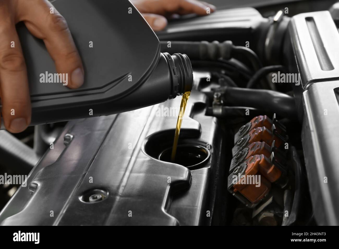 Male mechanic pouring motor oil from canister into car engine Stock ...
