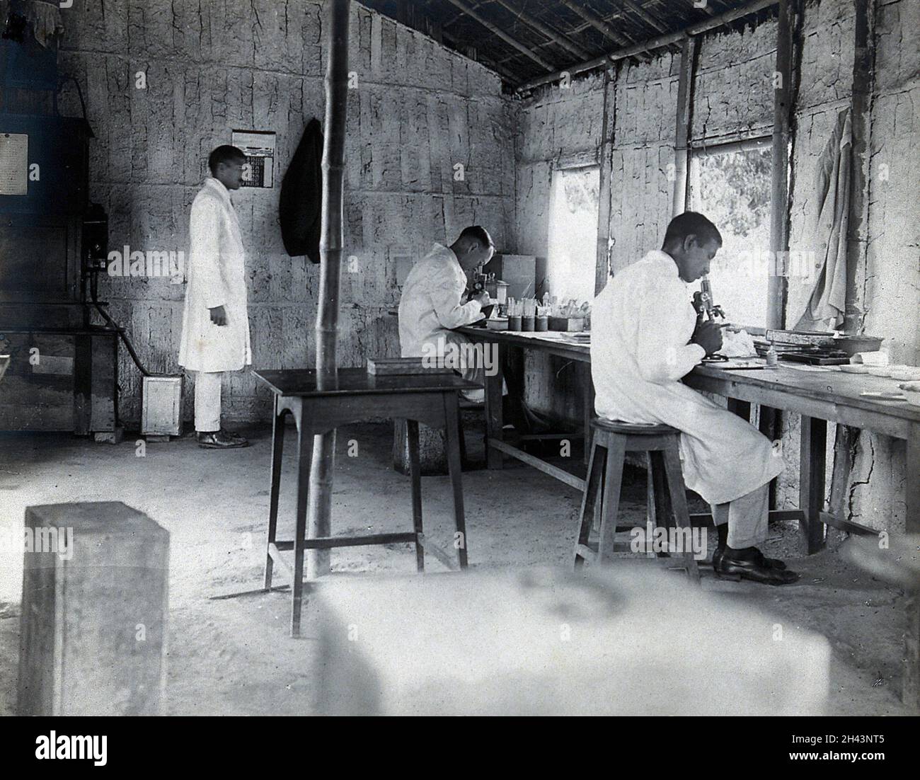 India: a field laboratory: scientists in white lab. coats work with ...