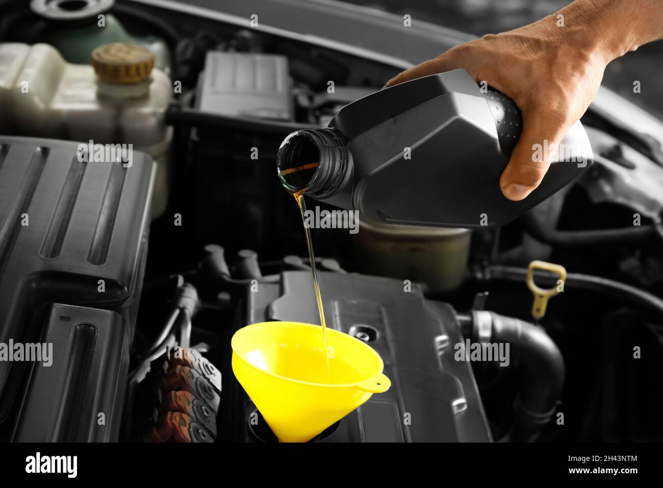 Male mechanic pouring motor oil from canister into car engine Stock ...