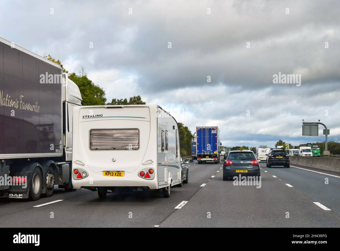 Midlands, England - October 2021: Car towing a caravan overtaking an ...