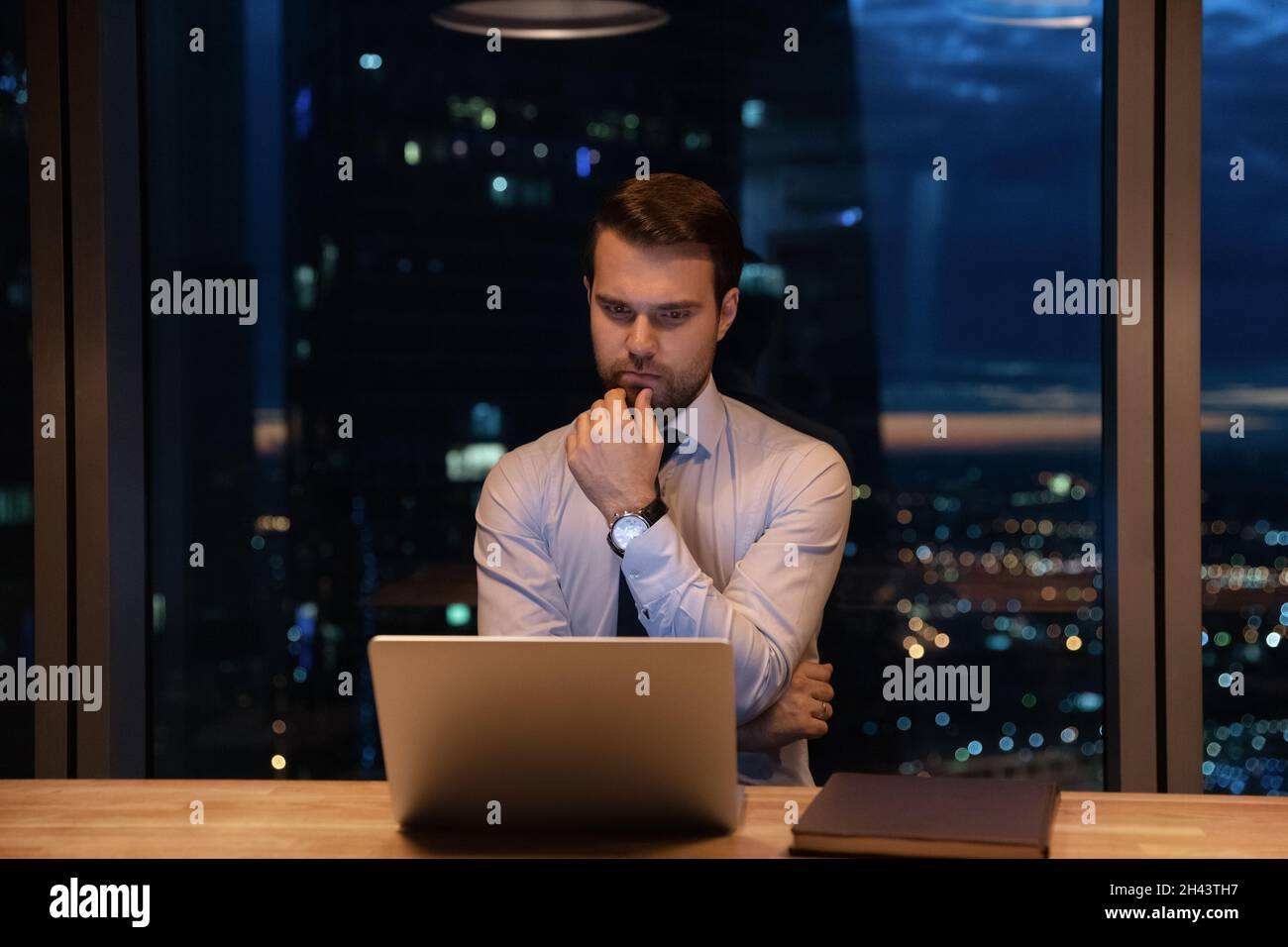 Stressed young 30s manager working on computer late in office Stock ...