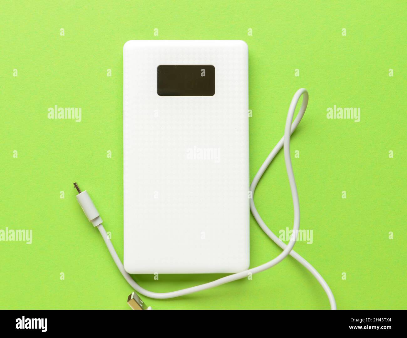 Modern power bank on green background Stock Photo - Alamy