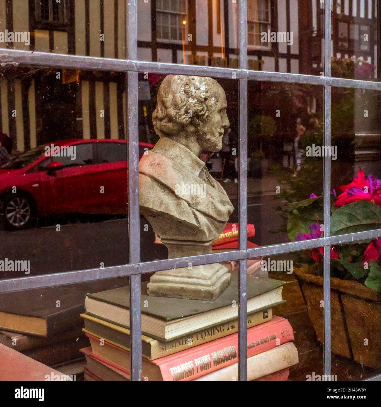 A bust of William Shakespeare standing on some books looks out of a ...
