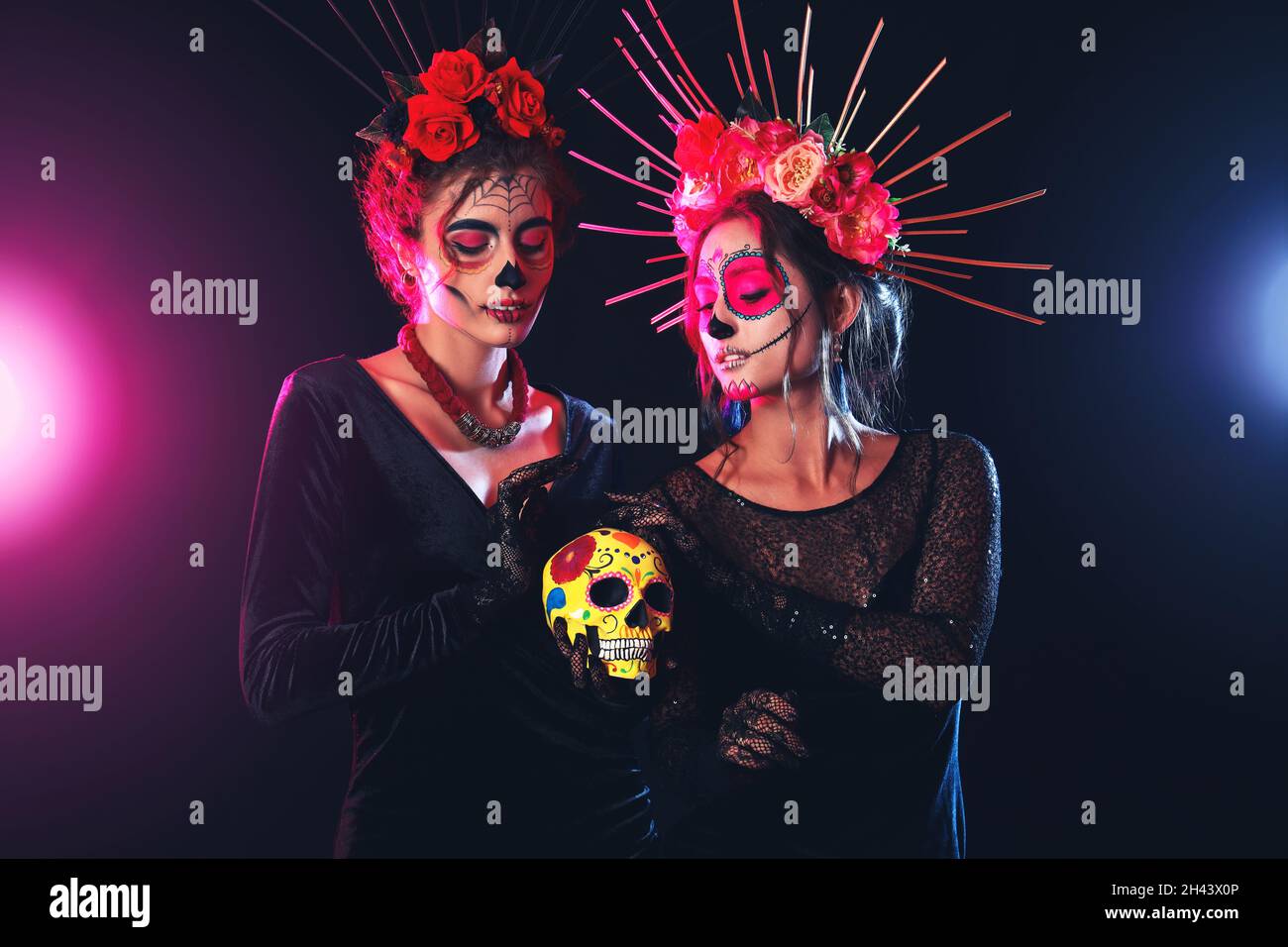 Stylish women with painted faces and sugar skull on dark background ...