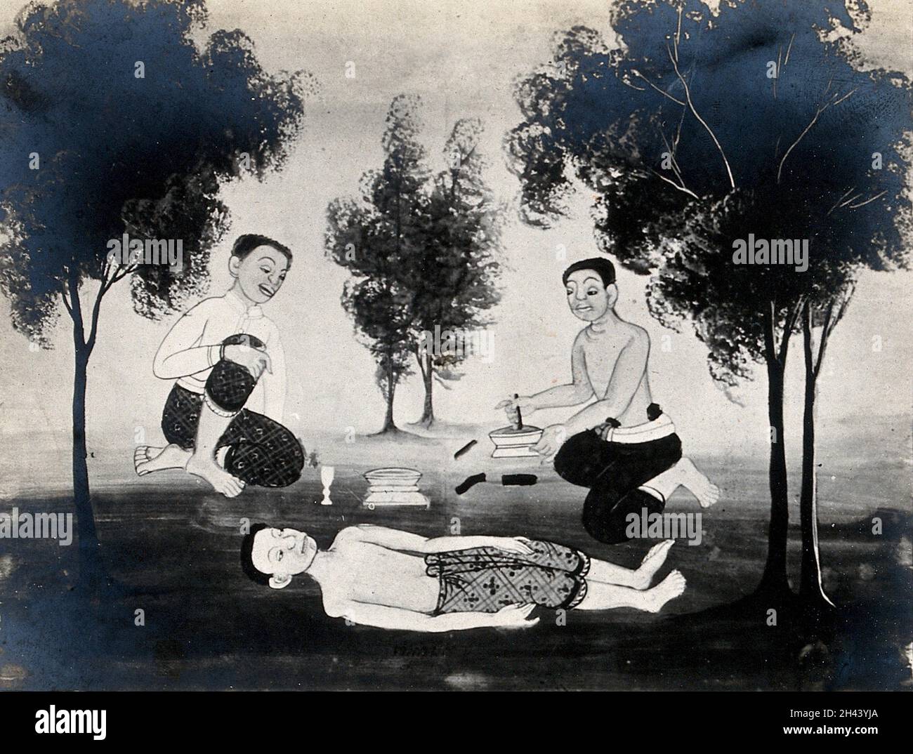 A patient lies between two kneeling men preparing to treat him ...