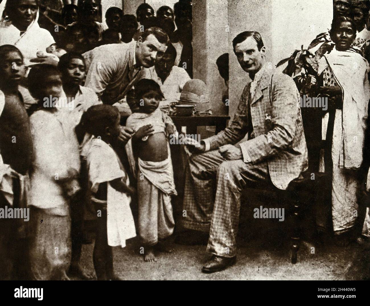 Inoculation against cholera: two men in suits prepare to inoculate a ...