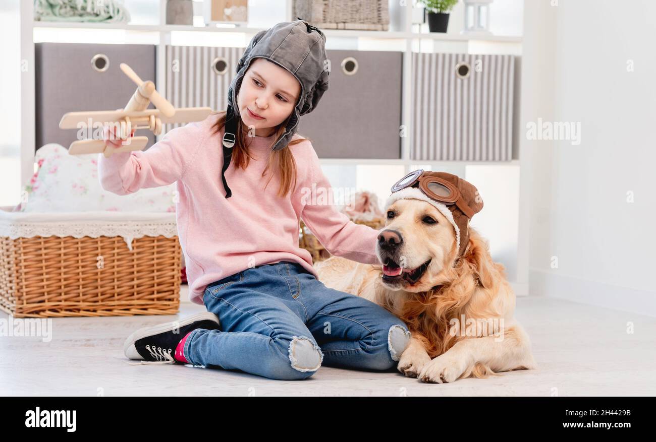 Little girl play in plane pilot with golden retriever dog Stock Photo ...