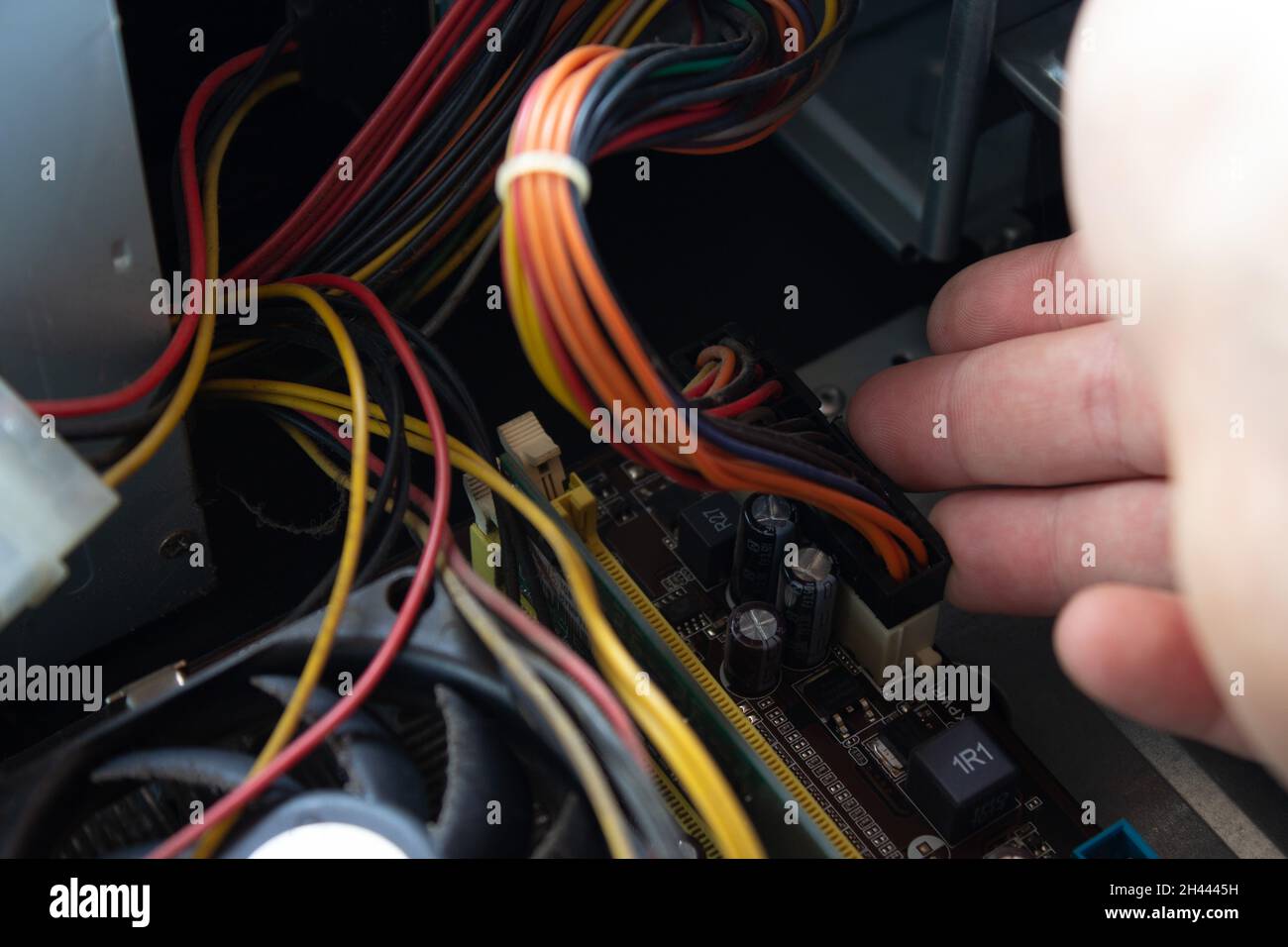Man hand putting electrical connections of a computer in right sockets ...