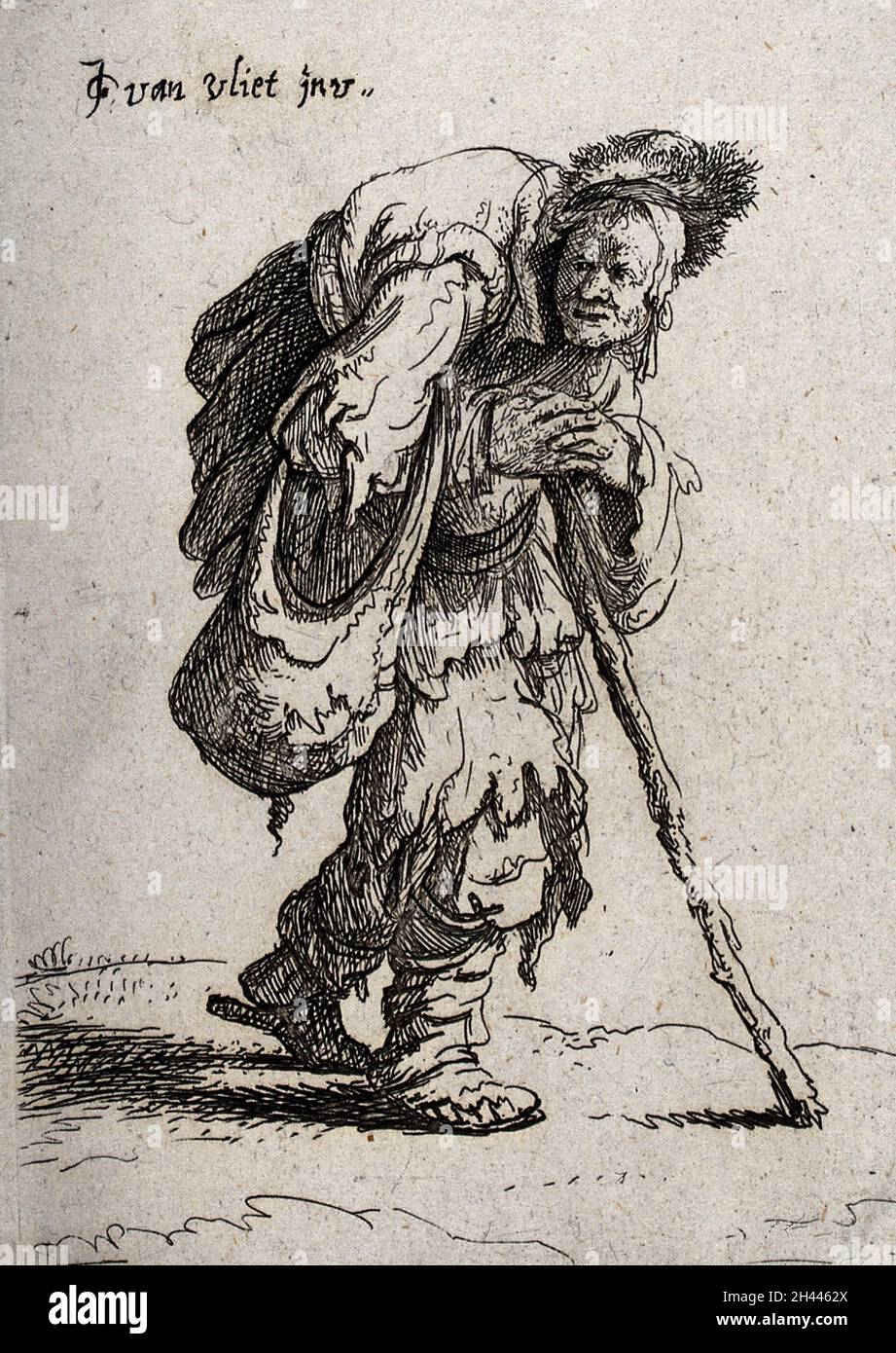 An old woman in ragged clothes carrying a huge load on her back ...