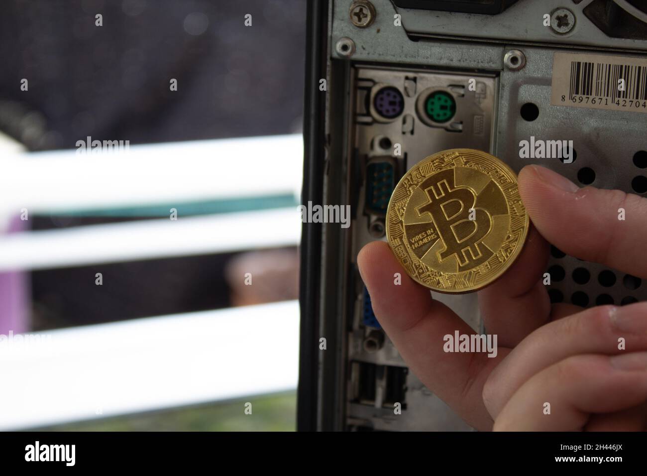 The back side of a computer with sockets, cables, and a bitcoin holding ...