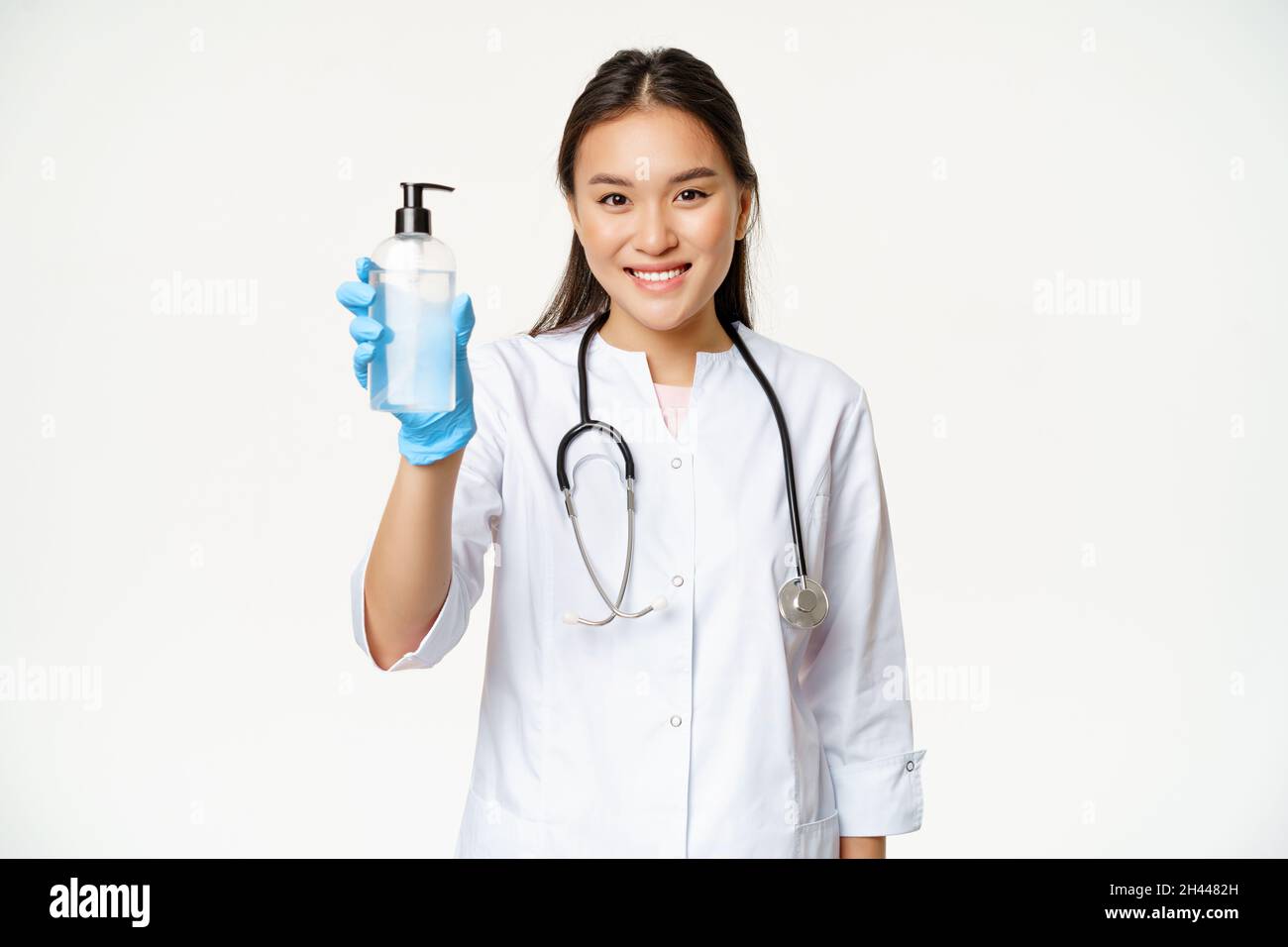 Smiling asian doctor showing hand sanitizer, bottle of antiseptic ...