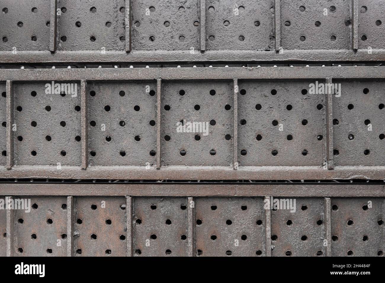 Old iron structures or plates with a round steel pattern of holes ...
