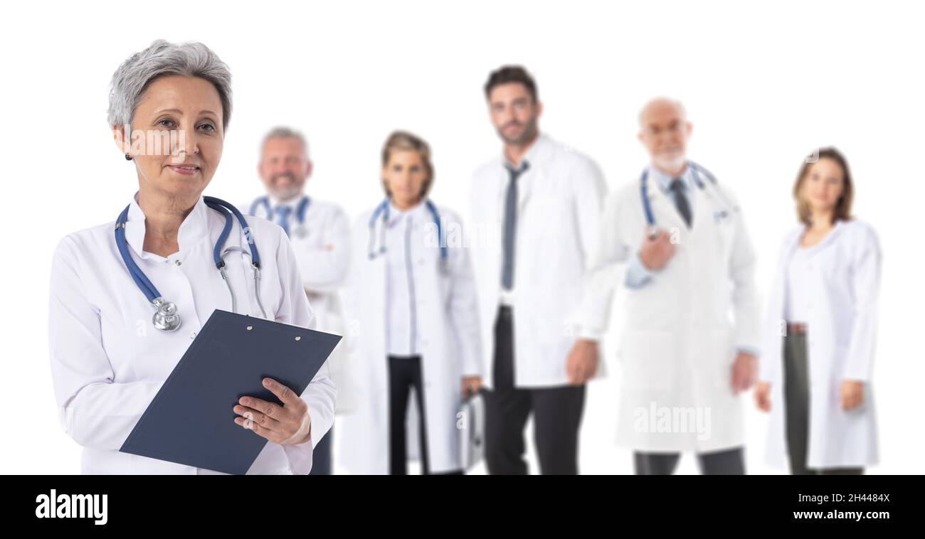 Team of doctors and asian mature female leader with folder in front ...