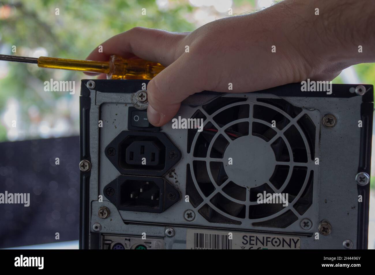 Pressing the on, off button on the power supply of a computer with a ...