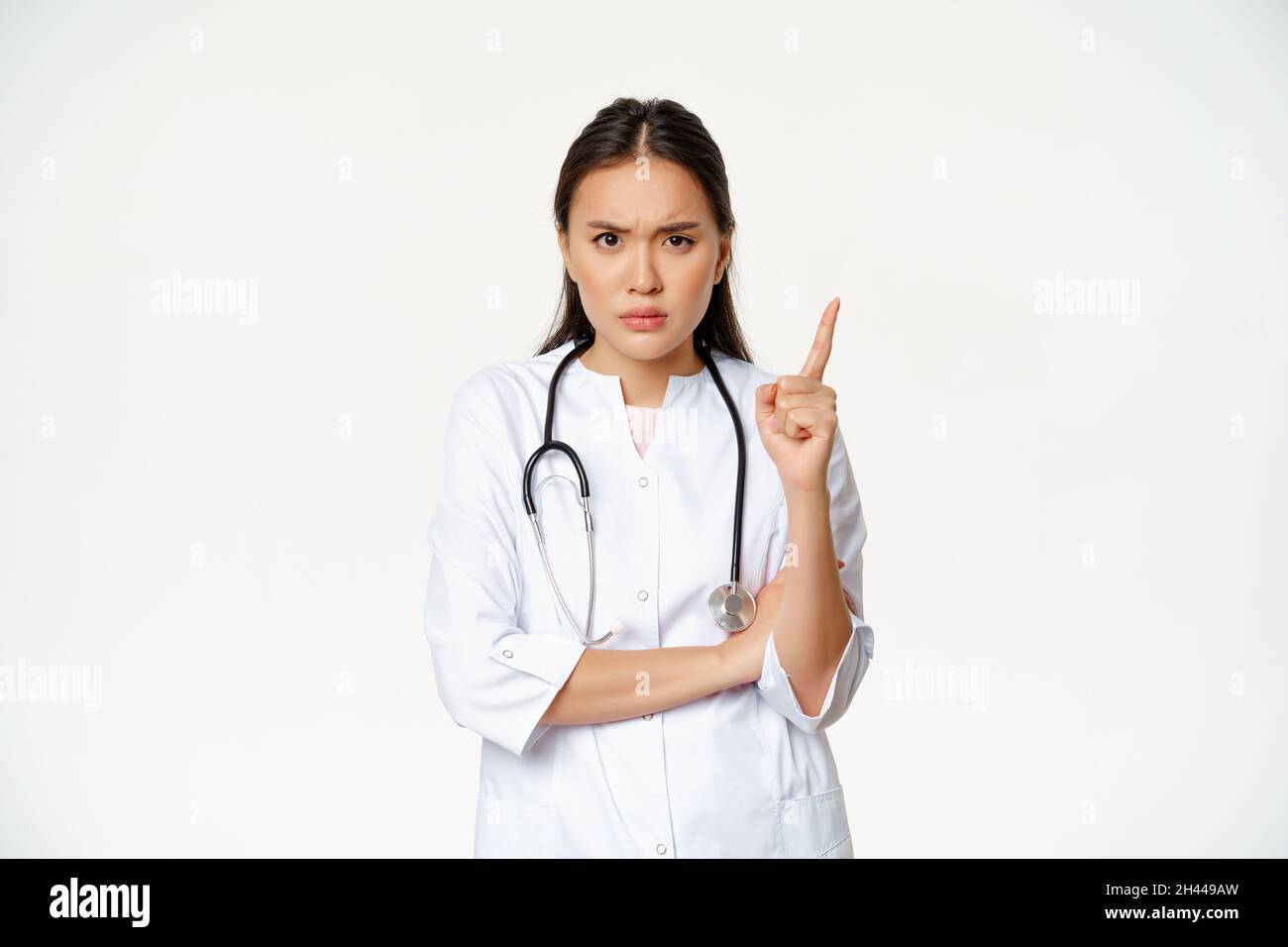 Doctor shows disapproval, scolding patient. Angry female asian ...