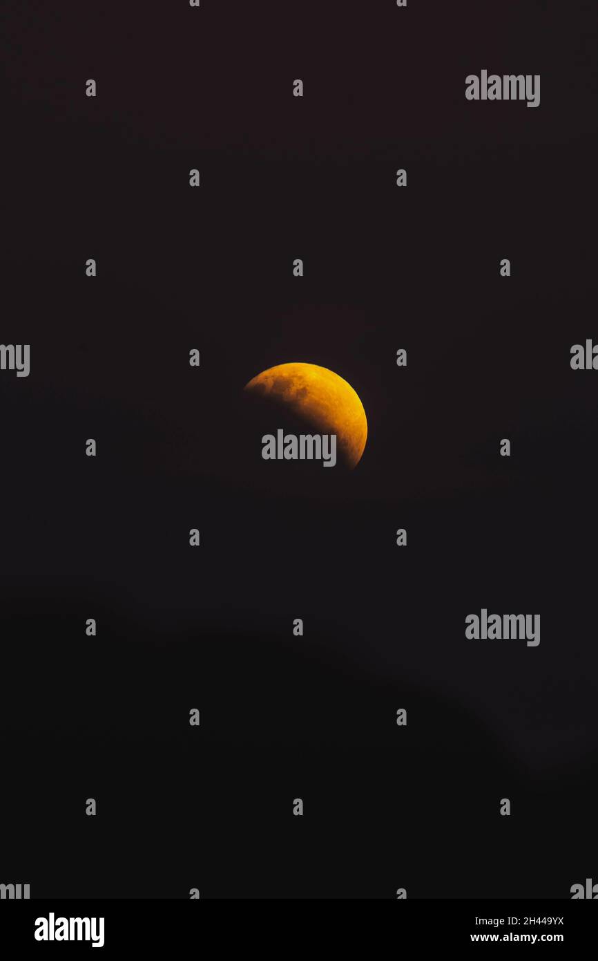 The partial eclipse ends of the moon in the dark night sky Stock Photo ...