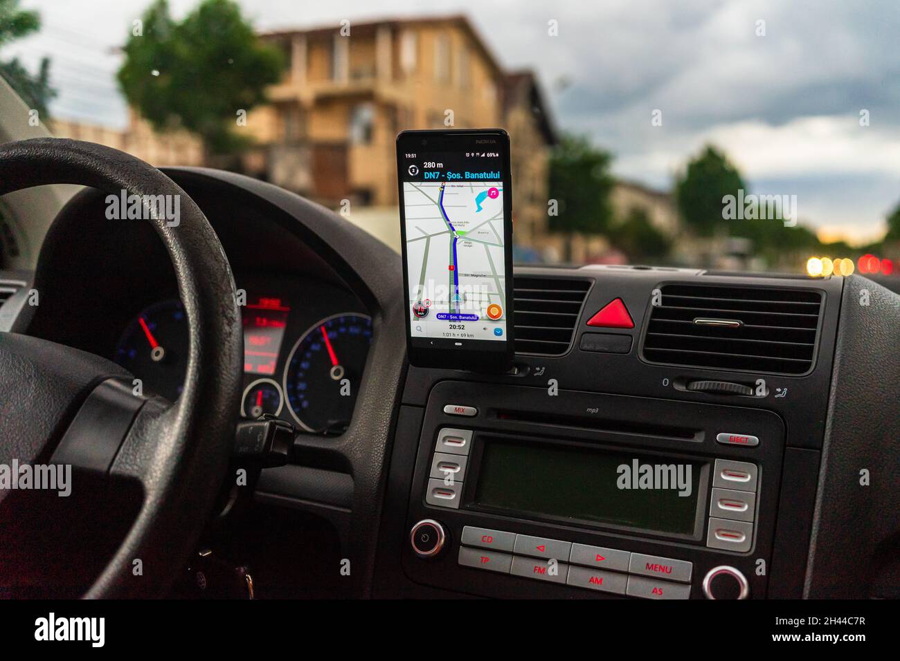 Driving and using waze maps application on smartphone on car dashboard ...