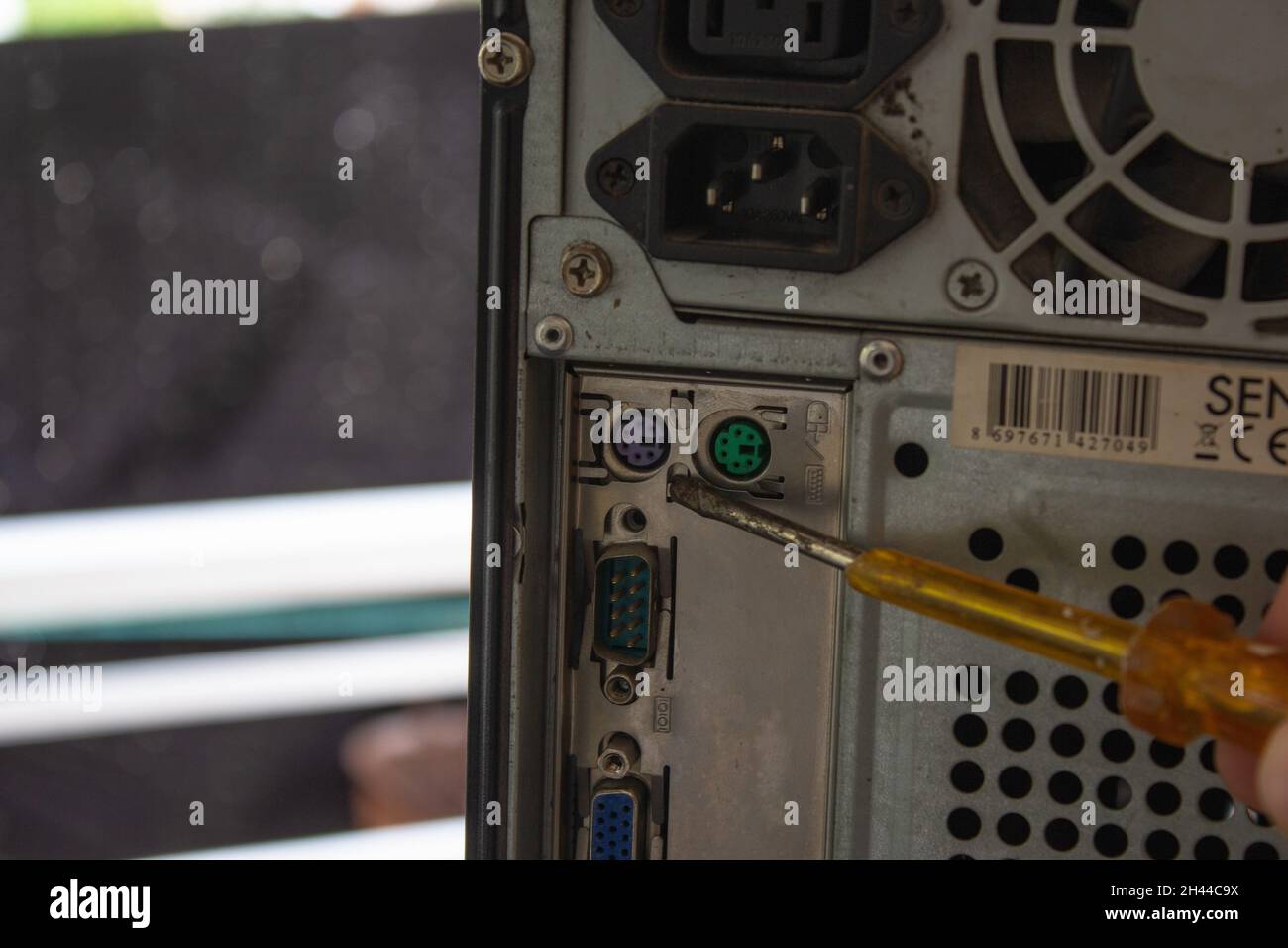 Pointing out the back sockets of a home computer with a yellow ...