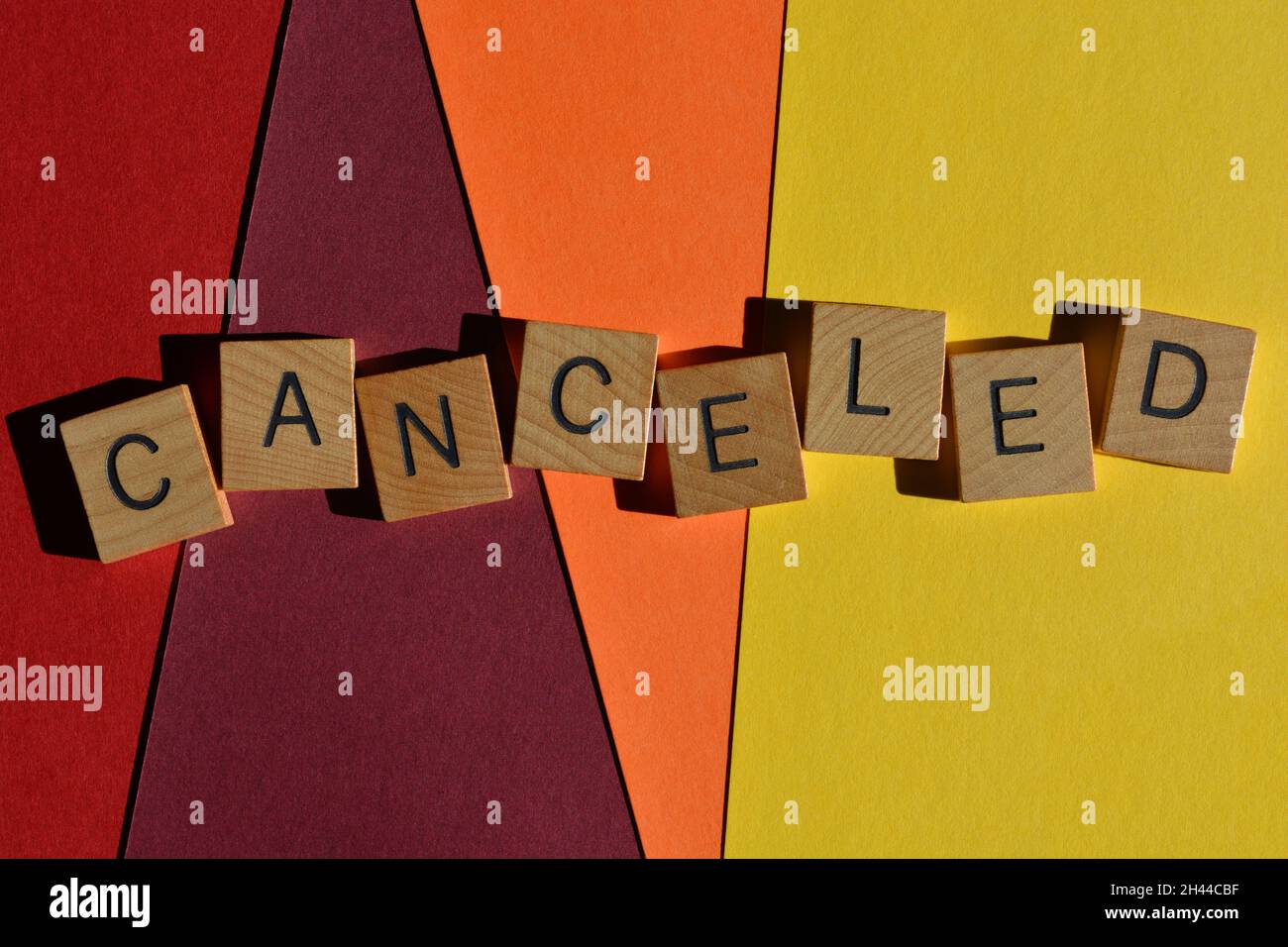 Canceled, word in wooden alphabet letters isolated on multi coloured ...
