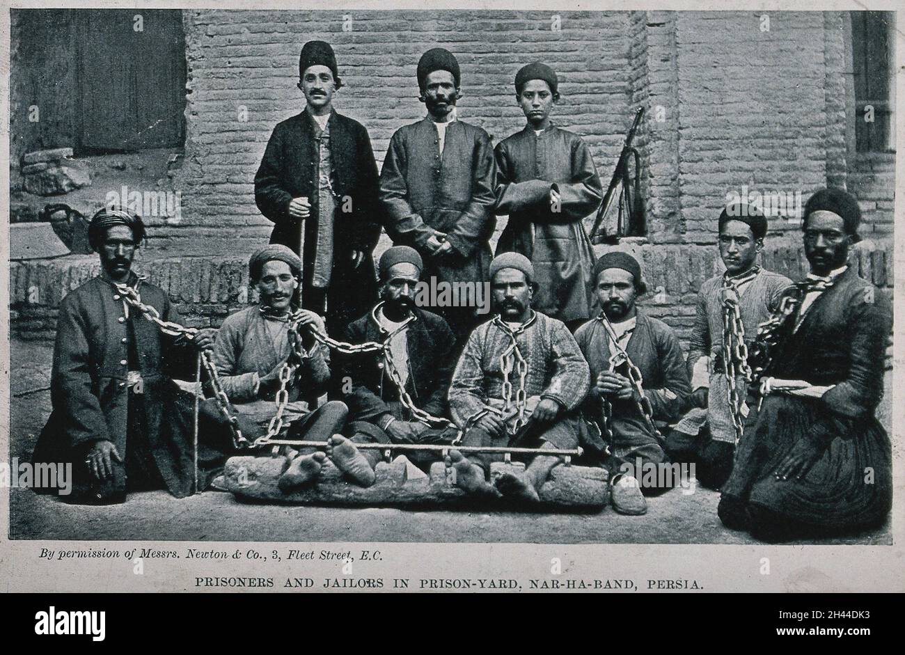 Seven prisoners in Persia sitting on the ground bound together by ...